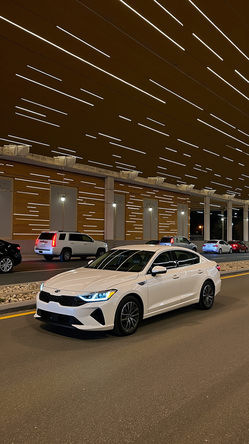 a white car parked in front of a building at night t...