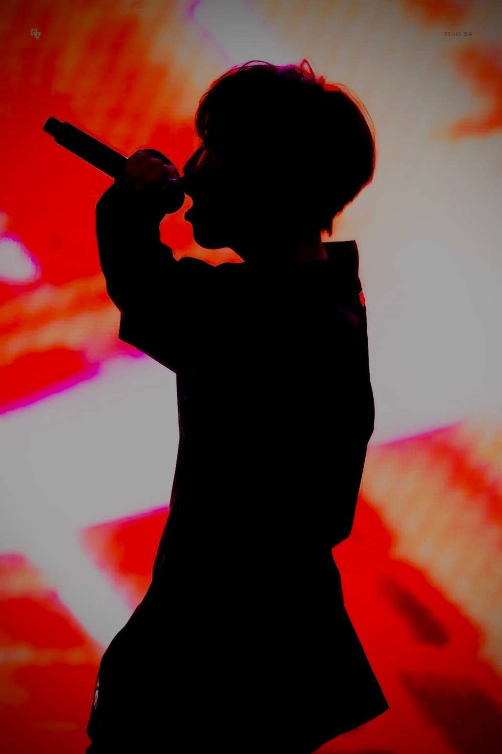 Han Jisung Stray Kids singing into a microphone with...